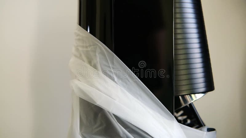 A Black Cylindrical Object is Gently Wrapped in a White Plastic Bag ...
