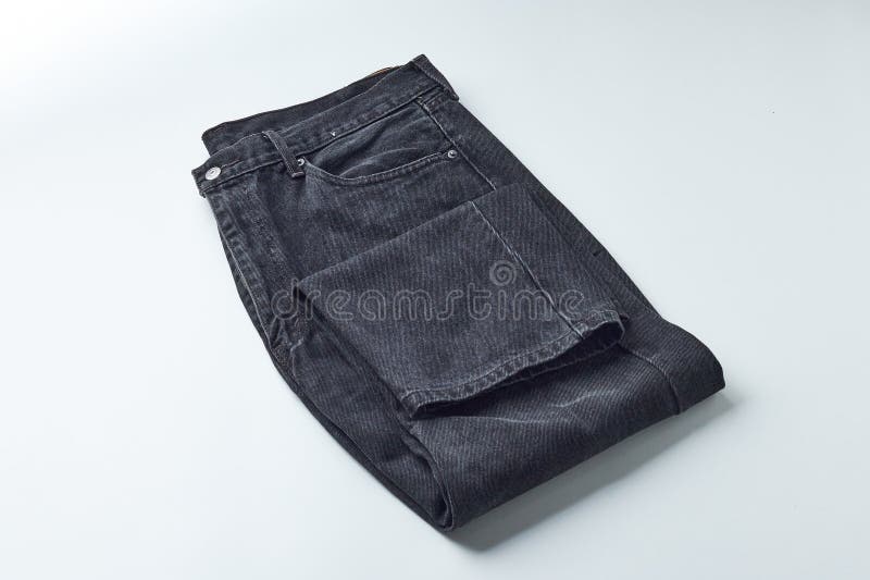 Folded Black Denim Jeans on a Light Surface Showcasing Texture and ...