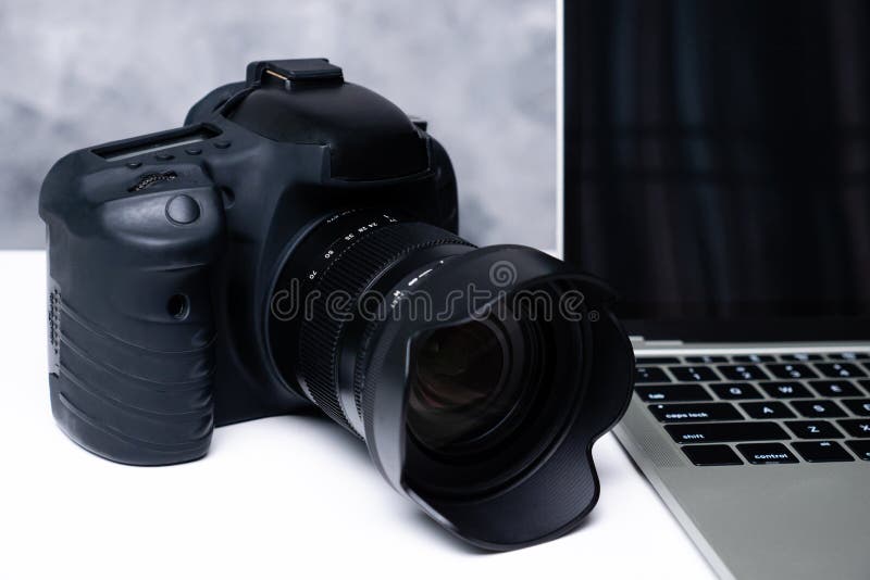 A Black Digital Camera and a Computer Laptop on Table Stock Photo ...