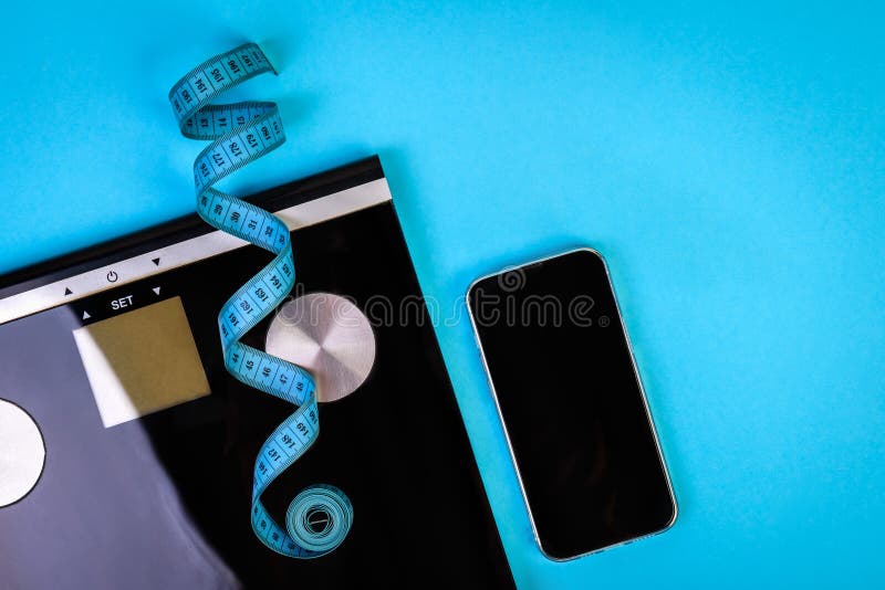 Black Digital Weight Scale, Tape Measure and Mobile Phone on Blue ...