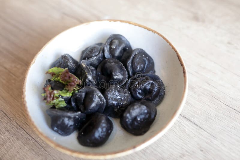 Black Dumplings Wit Bacon, Green And Cherry Tomatoes On Wooden B Stock ...
