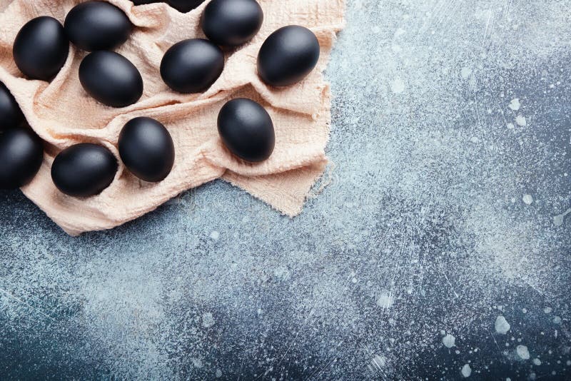 Black Easter Eggs on a Linen Napkin on a Blue Texture Table. Easter ...