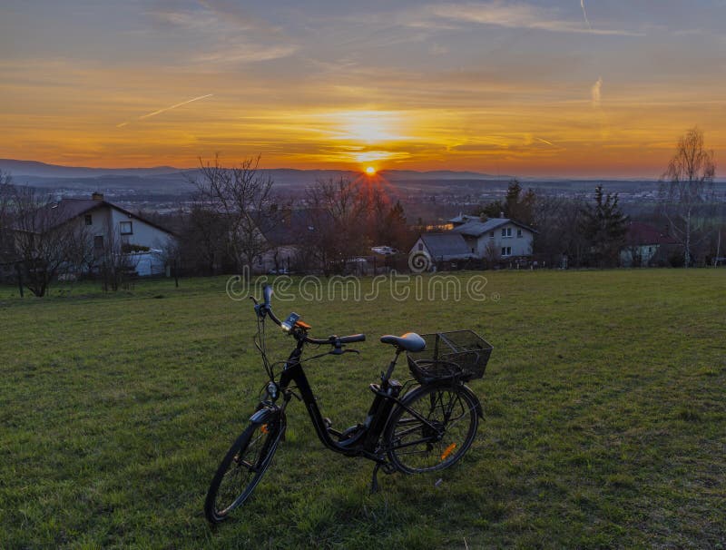 Black Electric Bicycle with Sunset on Light Green Meadow in Spring ...