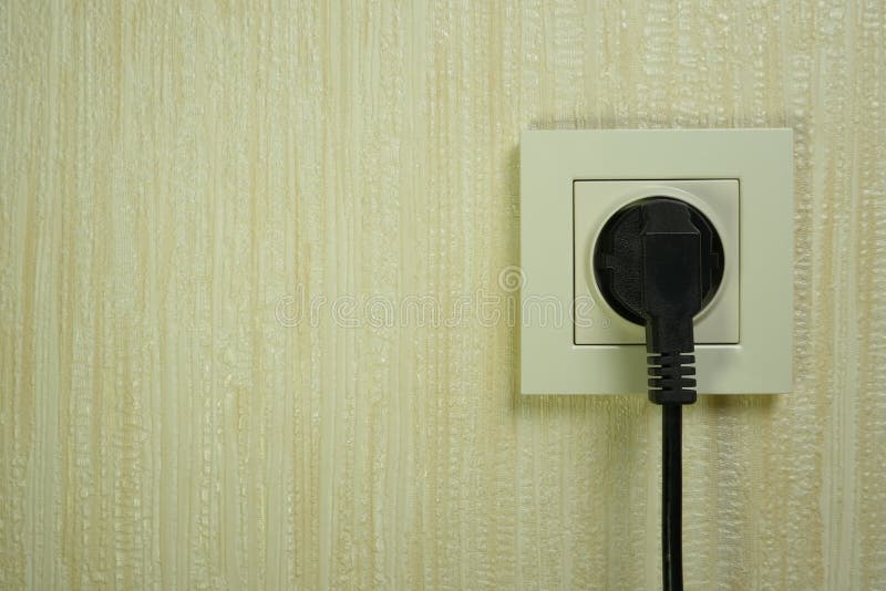 Black Electrical Plug in a White Plastic Socket on the Wall Stock Image ...