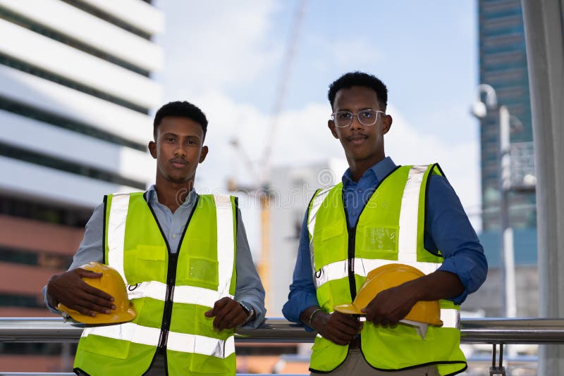 Black Engineer Team with Helmet and Glow Safety Shirt Standing and ...