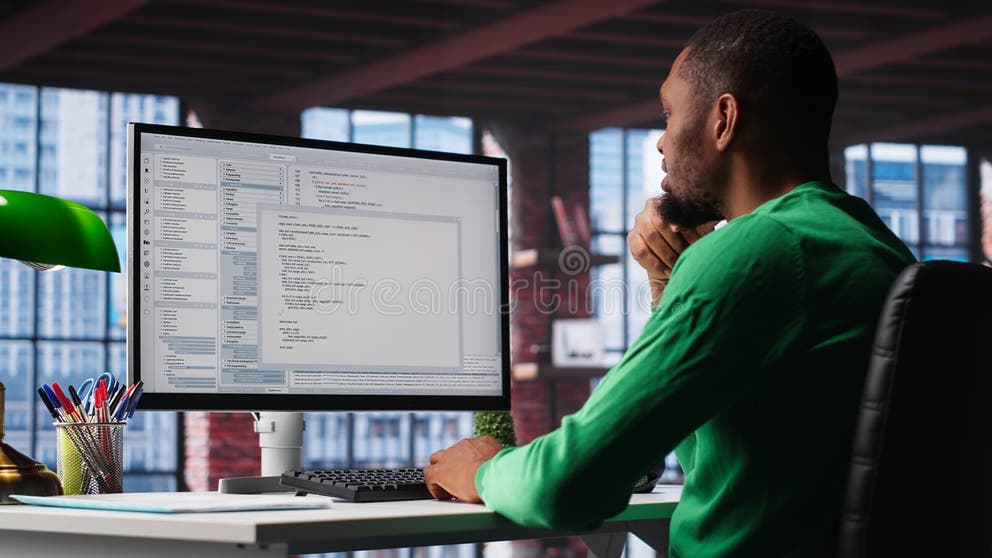Black it Expert Looking at User Interface on Computer at Home Office ...