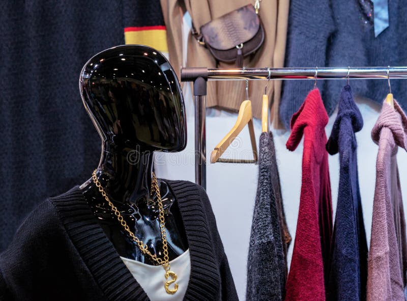 Black Female Mannequin and a Rack with Knitted Clothes in a Store Stock ...