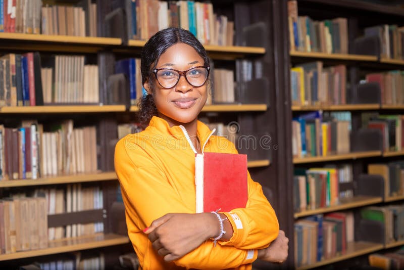 Black Female Student Holding a Red Book and Standing in the College ...