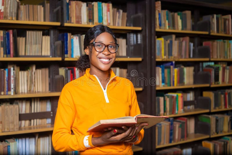 Black Female Student Holding a Red Book and Standing in the College ...