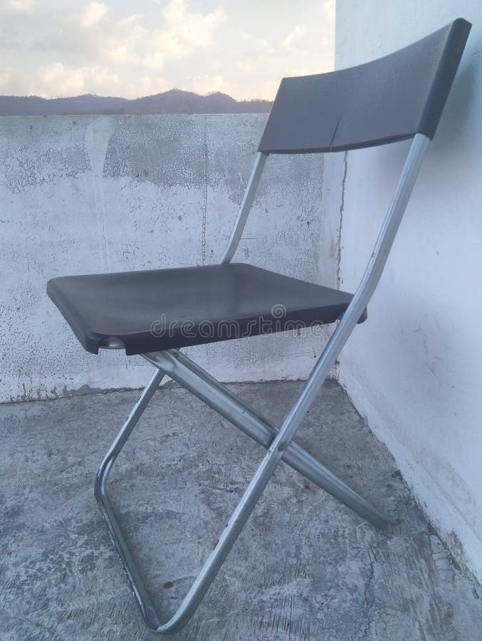 Black Folding Chair Close To Wall. Stock Image - Image of chair ...
