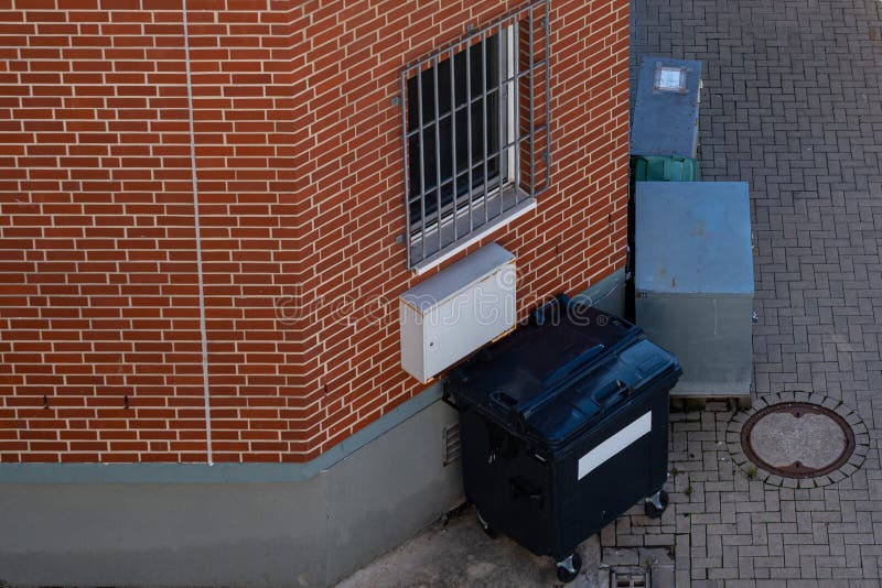 Black Garbage Container Standing Near the Wall of the House Stock Photo ...