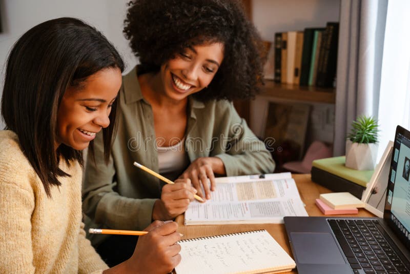 Black Girl Writing in Exercise Book while Doing Homework with Her ...