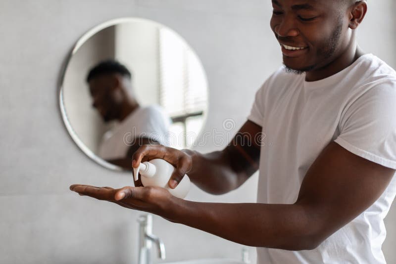 Black Guy Using Liquid Soap from Bottle in Modern Bathroom Stock Image ...