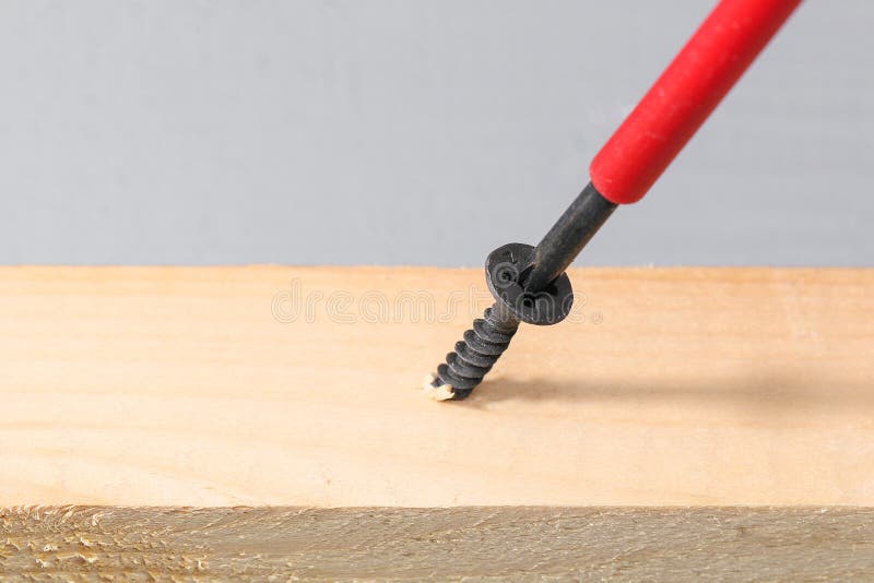 Black Iron Screws Screwed into Wood with Screwdriver. Fasteners and ...