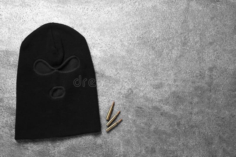 Black Knitted Balaclava and Bullets on Grey Table, Flat Lay. Space for ...