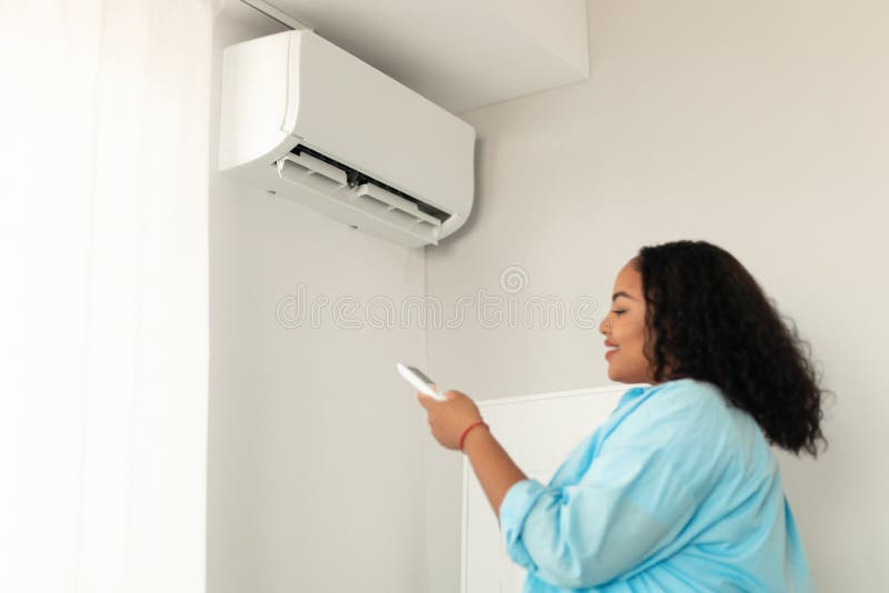 Black Lady Turning on AC with Remote Controller at Home Stock Photo ...