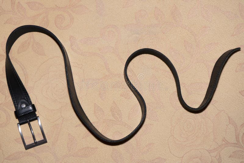 Black Leather Belt with a Steel Patch on a Beige Bedspread. Stock Photo ...