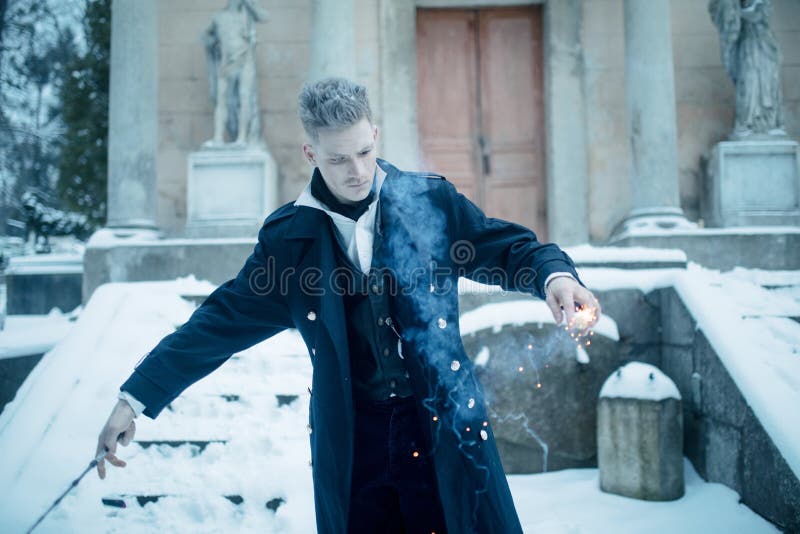 Young Man in Image of Black Magician Walks on Street with Magic Wand ...
