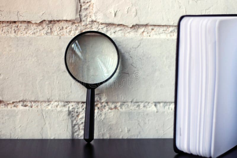 Magnifying Glass Next To a Black Notebook. Stock Image - Image of black ...