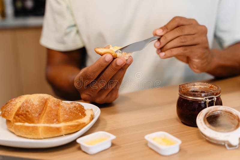 Black Man Eating Croissant with Butter while Having Breakfast Stock ...
