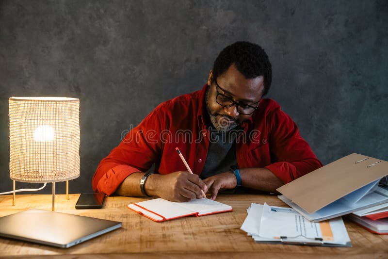 Black Man in Eyeglasses Writing Down Notes while Working in Office ...