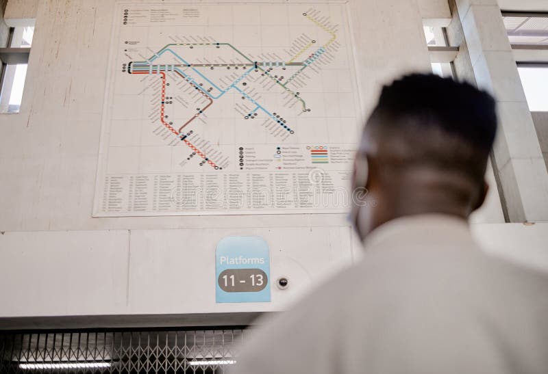 Black Man Looking at a Map while Travelling in a Station. Reading a Map ...
