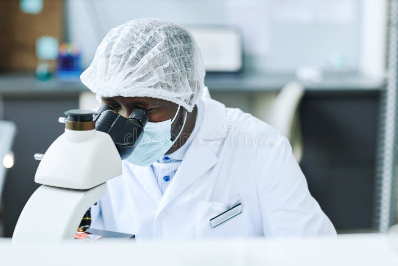 Black Man Looking in Microscope and Working on Research in Lab Stock ...