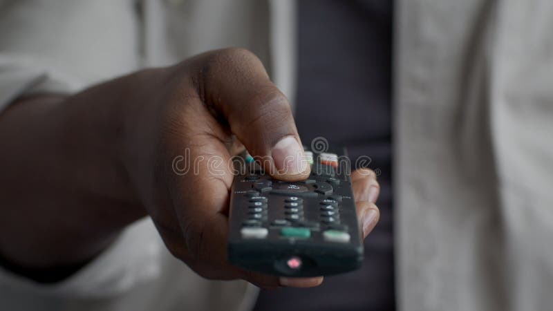 Black Man Pushing Button on TV Controller Switching Channels, Closeup ...