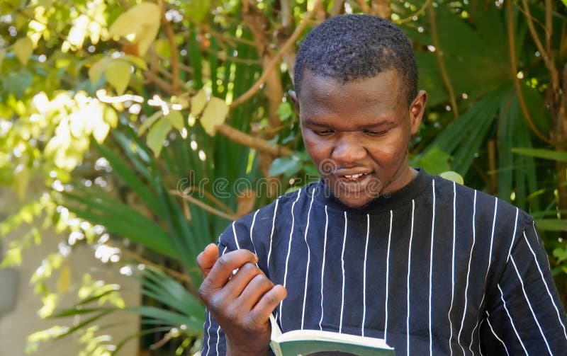 Black Man Reading a Book Outside. African Person Looking at Book Stock ...