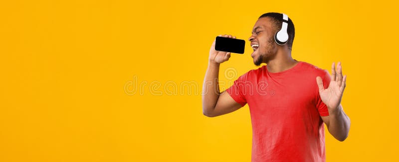 Black Man Singing Holding Smartphone Like Microphone on Yellow ...