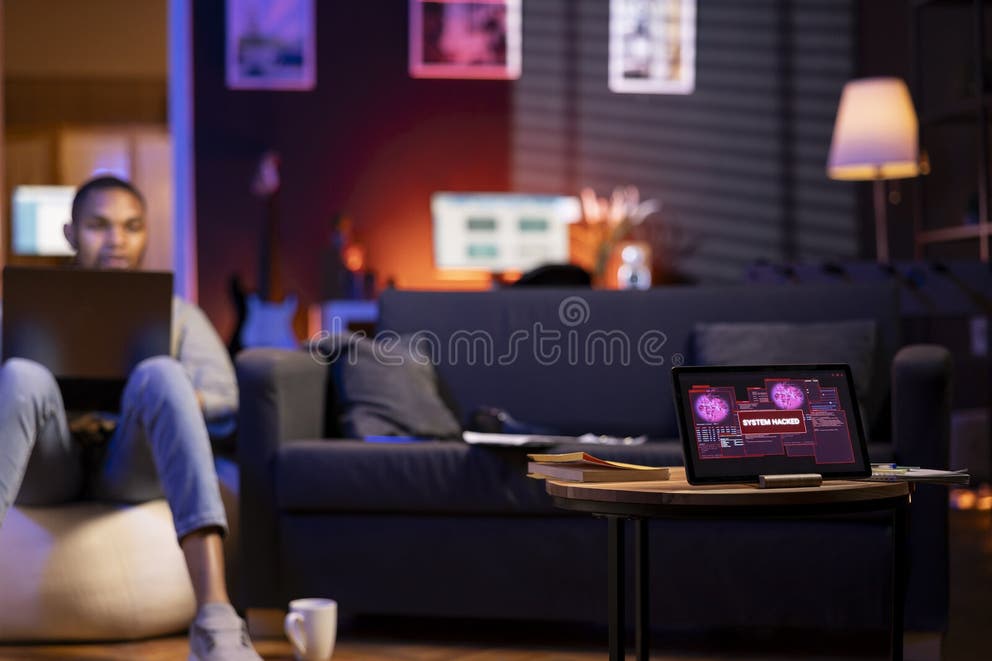 Black Man Sitting on a Bean Bag Coding on His Laptop for Cyber Security ...