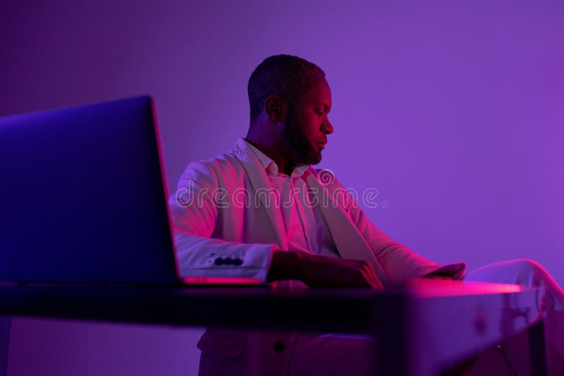 Black Man Sitting at the Computer in the Evening Office. it Worker in ...