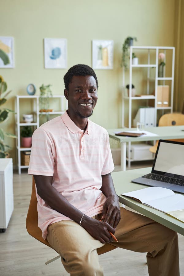 Black Man Smiling at Camera at Desk in Office Stock Photo - Image of ...
