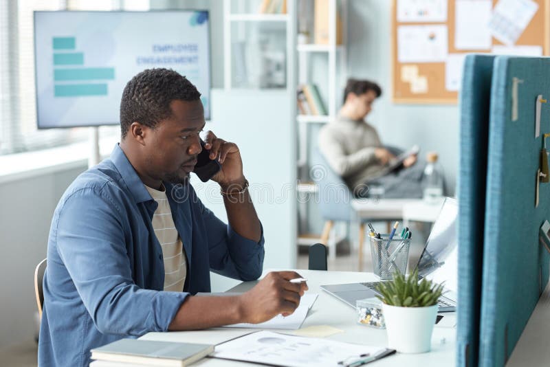 Black Man Speaking on Phone Working at Desk in Office Stock Photo ...