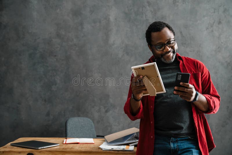 Black Man Using Mobile Phone while Working in Office Stock Photo ... Black Man Using Mobile Phone while Working in Office Stock Photo ...