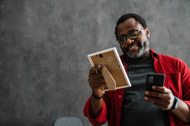 Black Man Using Mobile Phone while Working in Office Stock Photo ...