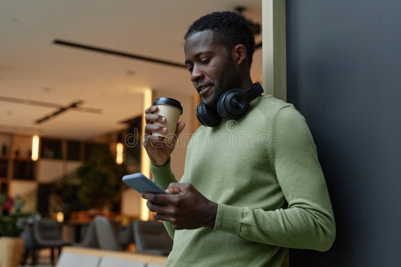 Black Man Using Smartphone and Drinking Coffee Stock Photo - Image of ...