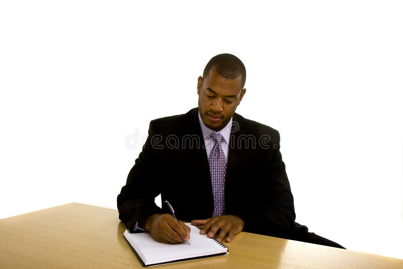 Black Man Writing at Desk Looking Down Stock Photo - Image of suit ...