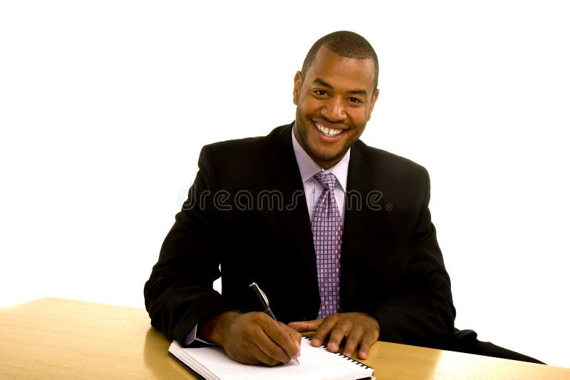 Black Man Writing at Desk and Smiling Stock Photo - Image of ...