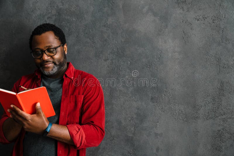 Black Man Writing Down Notes while Leaning on Concrete Wall Stock Image ...