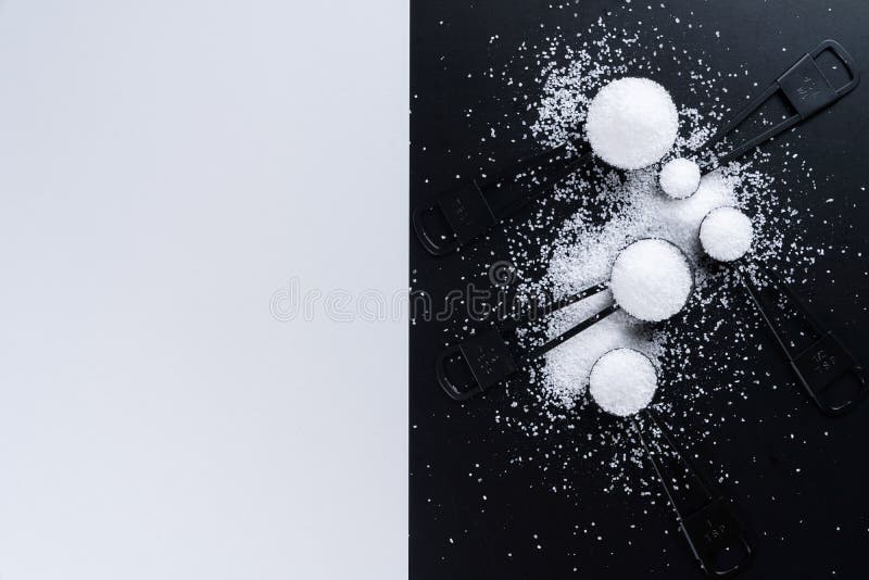 Black Measuring Spoons with Salt on Black and White Background Stock ...