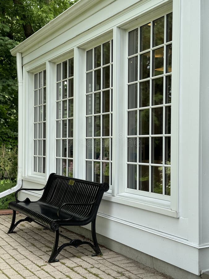 Black Metal Bench in Front of White Building with Large Windows Stock ...