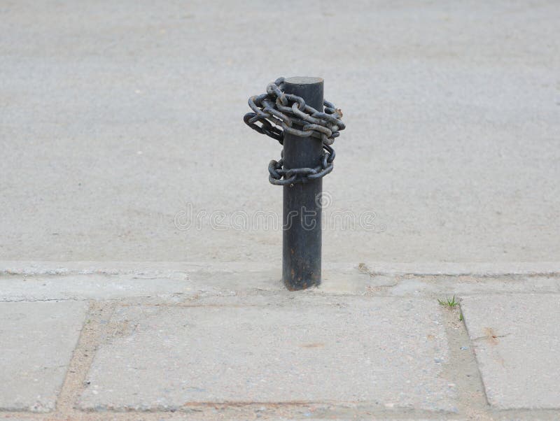 Black Metal Post Driven into the Pavement is Wrapped with a Metal Chain ...