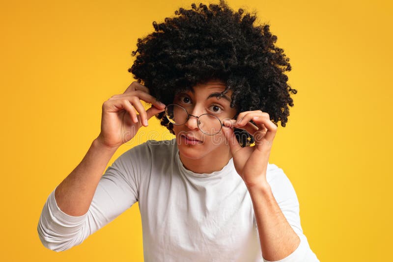 Black Millennial Guy Looking Skeptically, Lowing His Glasses Stock ...