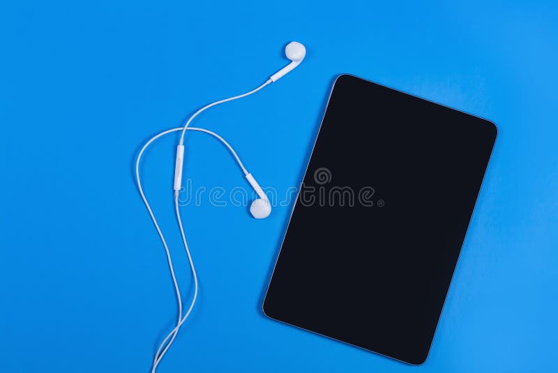 Black Mini Tablet with Headphones on a Blue Background Stock Photo ...
