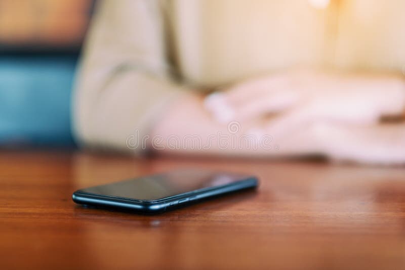 Phone on the Table with a Woman Sitting in Background Stock Image ...