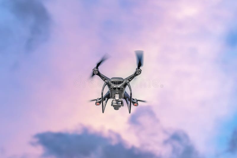 A Modern Drone with a Camera Flies in the Blue Sky. Generated by ...