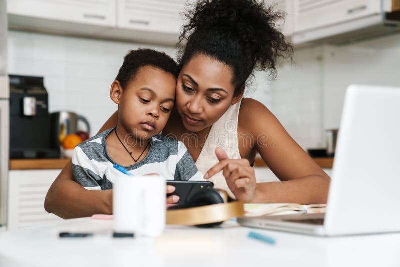 Black Mother and Son Using Mobile Phone while Sitting Together Stock ...