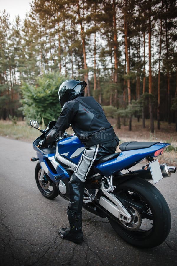 Motorcycle Driver in Leather Suit and Helmet Sits in Front of the ...