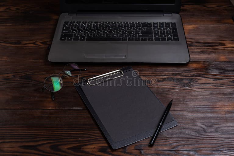 Black Notepad on the Table. Glasses and Pen on the Table. Desktop with ...